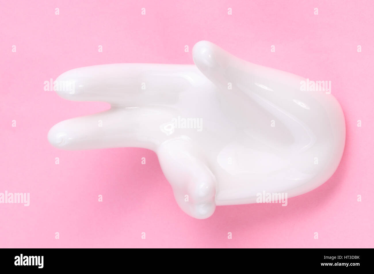 Ceramic stand with hand shape on pink background Stock Photo - Alamy