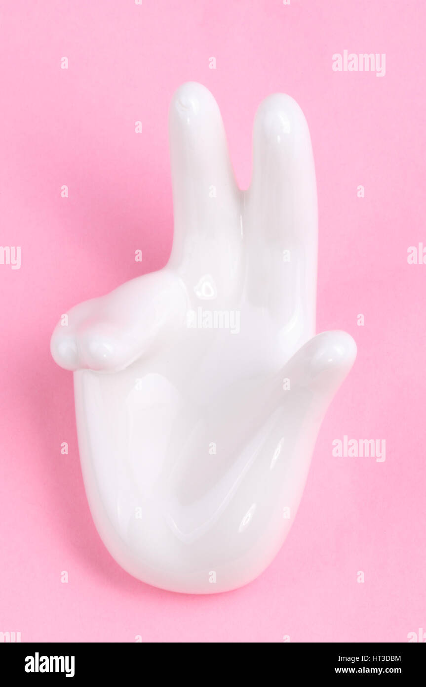 Ceramic stand with hand shape on pink background Stock Photo - Alamy