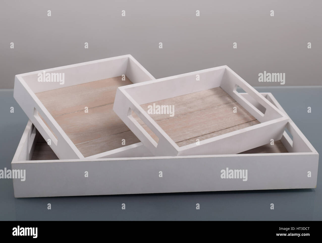 White wooden trays on gray background Stock Photo - Alamy