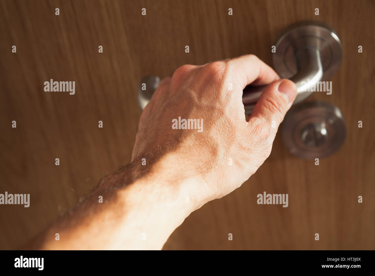 Male hand opens wooden door with steel modern handle, close up photo ...