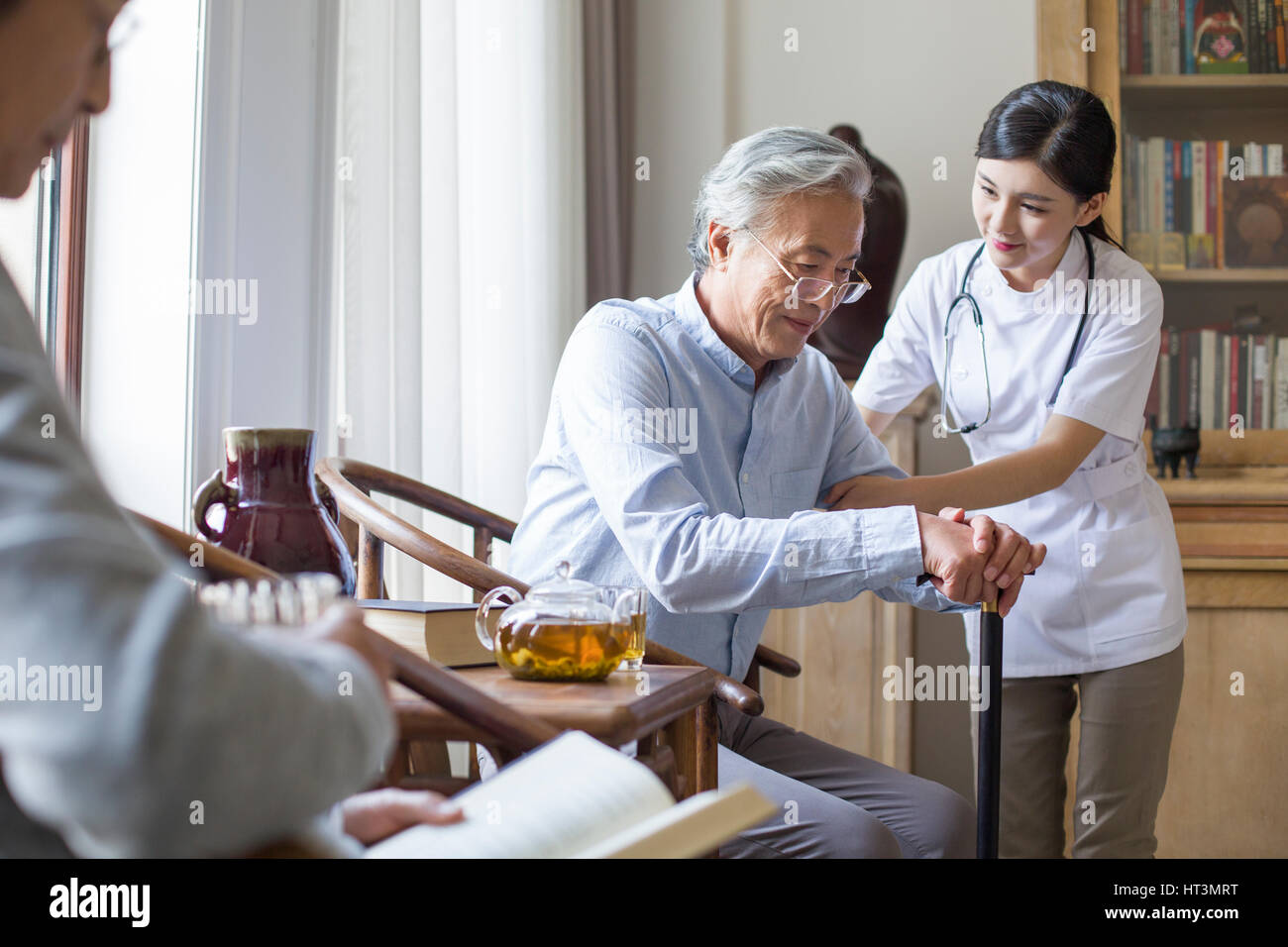 Nursing assistant taking care of senior man Stock Photo - Alamy