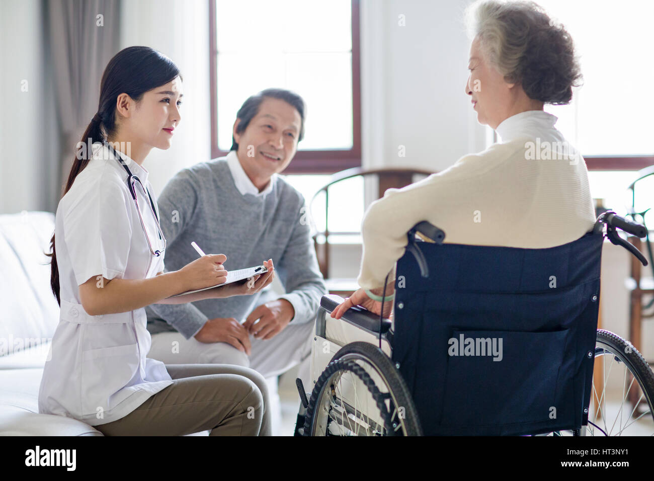 Nursing assistant taking care of senior woman in wheel chair Stock ...