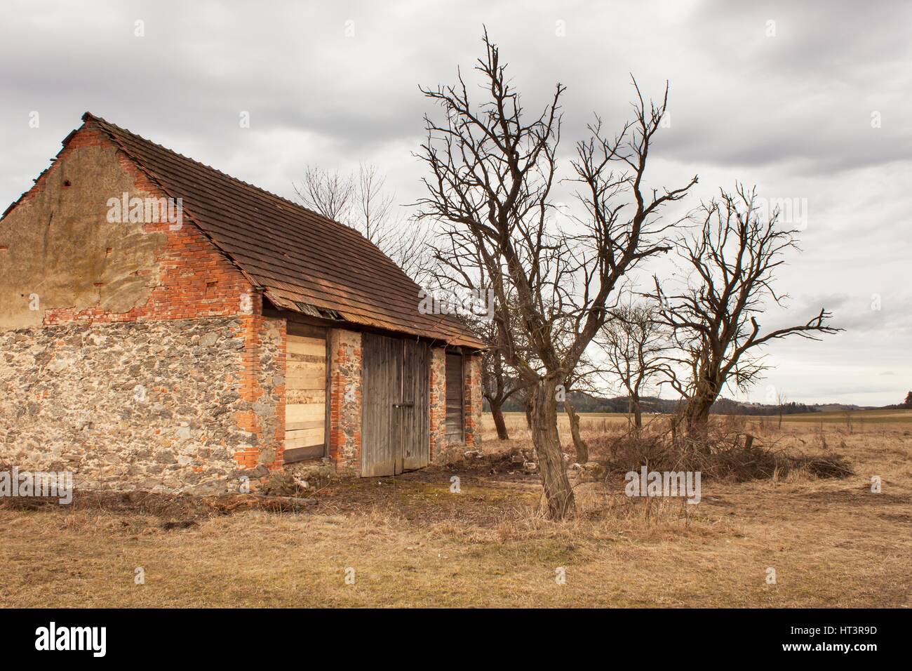 The old barn in the countryside. Farm buildings. Overcast sky above the ...