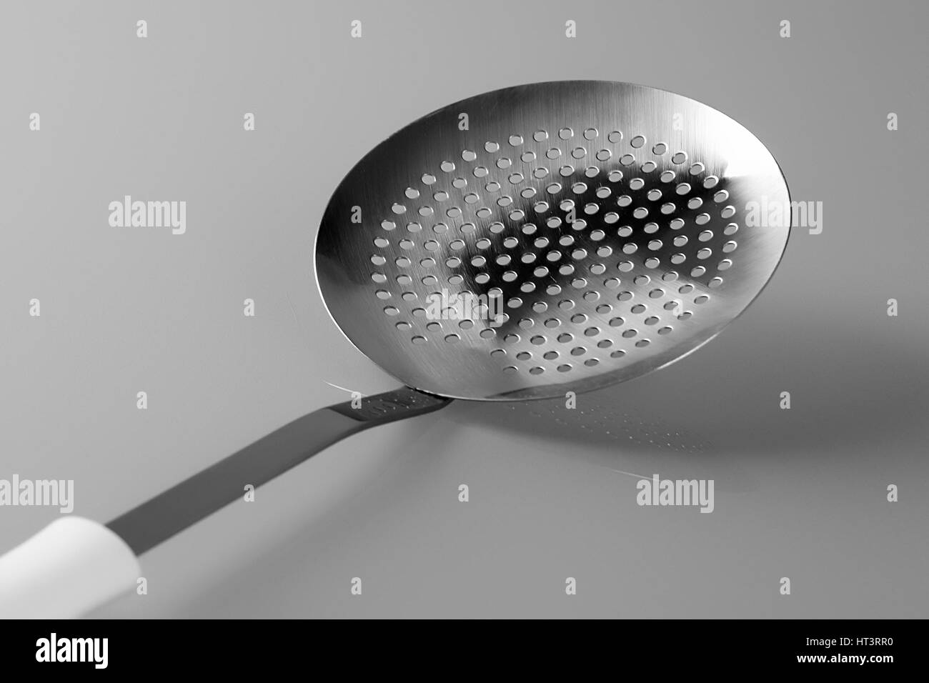 Metal skimmer with plastic handle Stock Photo - Alamy