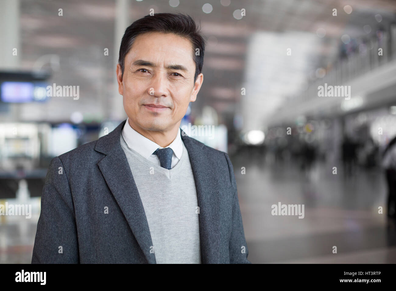 Businessman in airport lobby Stock Photo - Alamy
