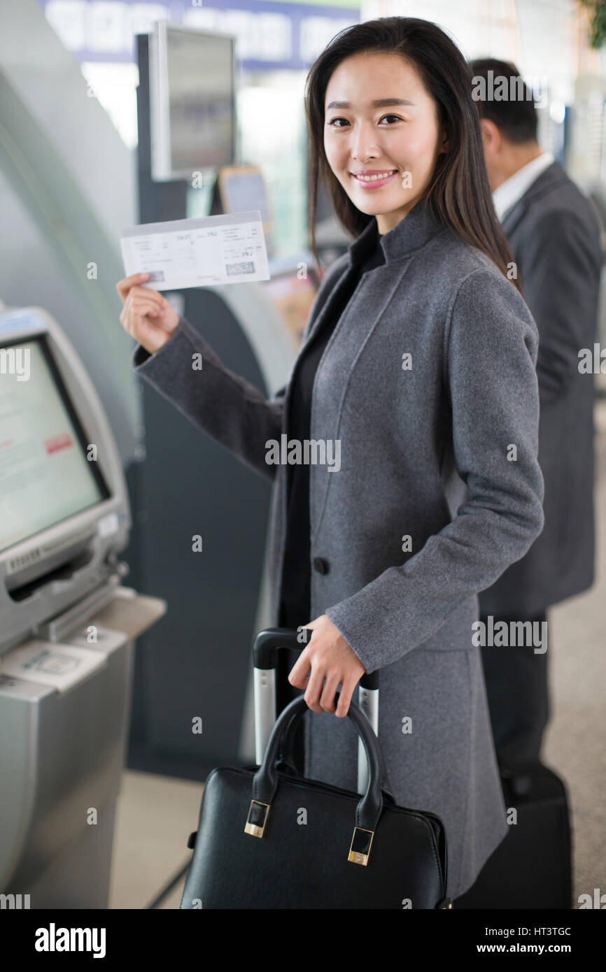 Businesswoman using ticket machine at the airport Stock Photo - Alamy