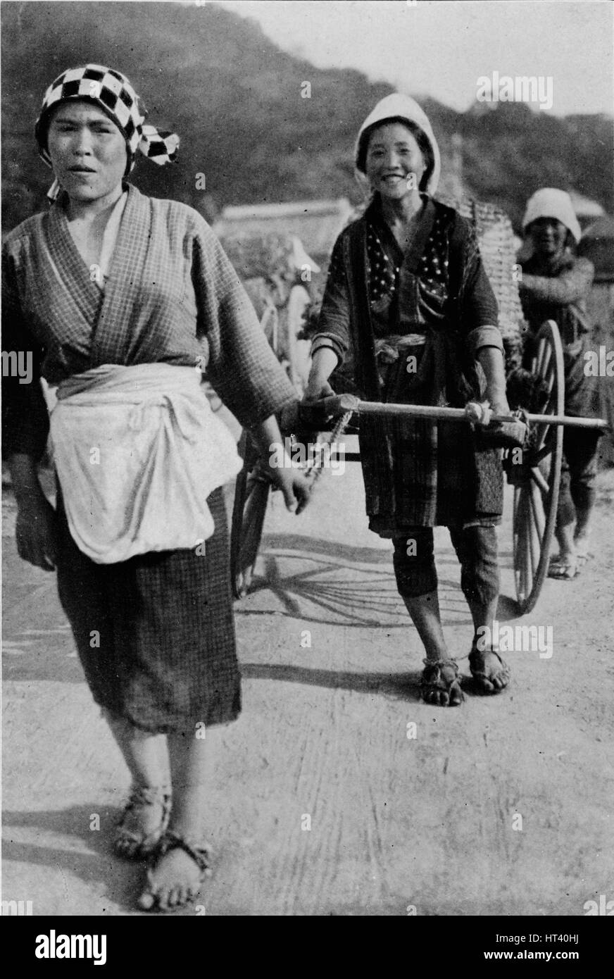 ''Three generations of women moving a cart with grandmother at the rear ...