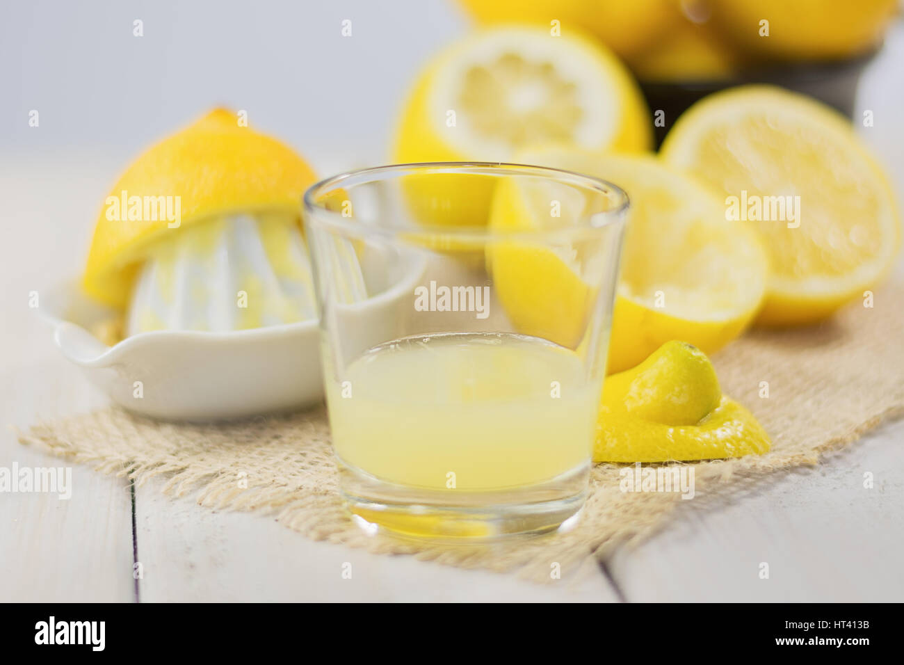 A glass of squeezed lemon juice and lemons around Stock Photo - Alamy