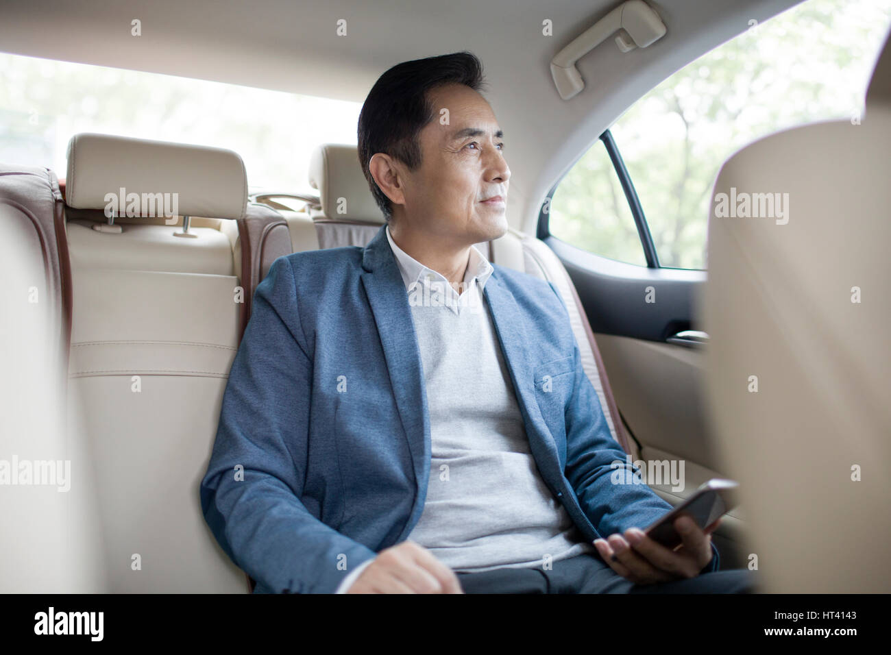 Businessman holding a smart phone inside car Stock Photo - Alamy
