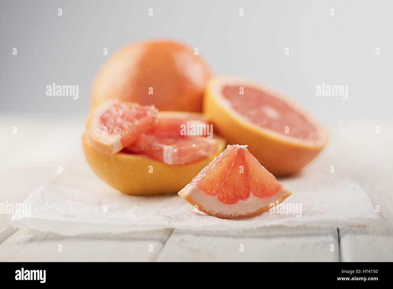 Sliced grapefruit with a paper and a half in the background Stock Photo ...