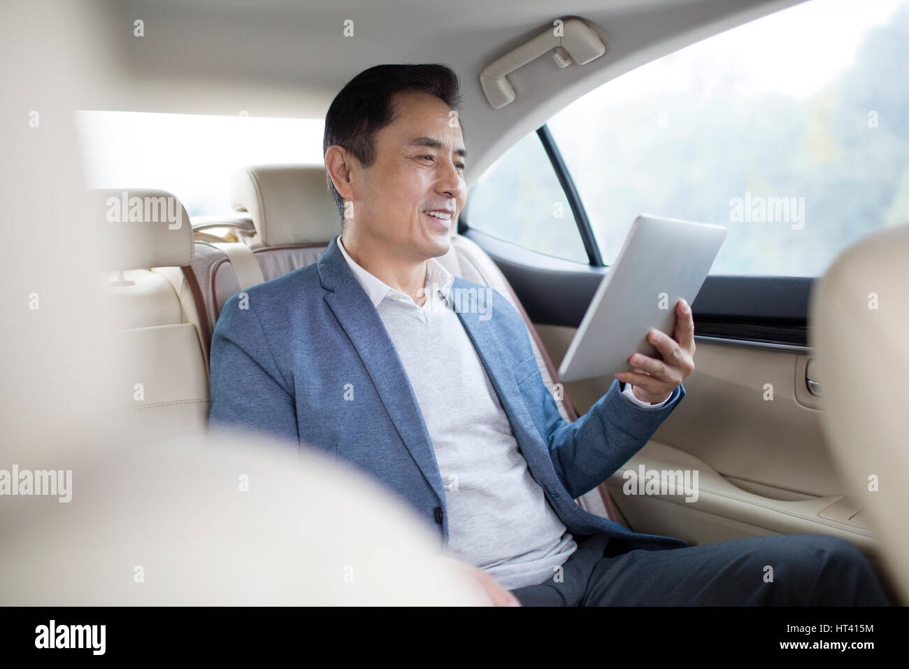 Businessman using digital tablet inside car Stock Photo - Alamy