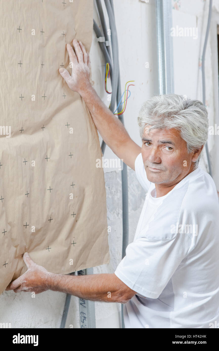 Worker putting insulation on Stock Photo - Alamy