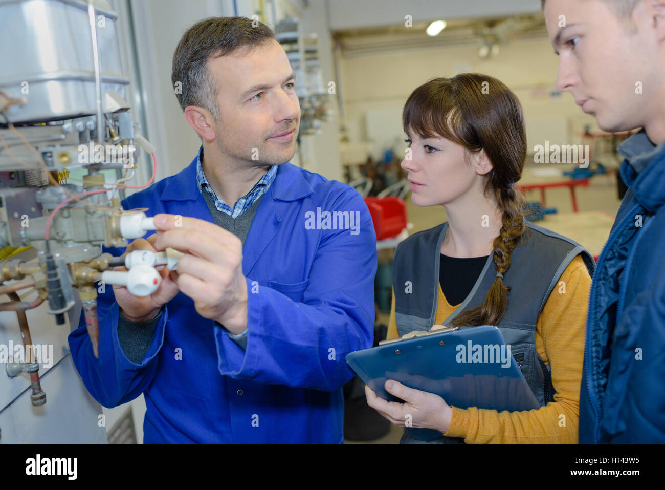 teachers and students checking machinery procedure Stock Photo - Alamy