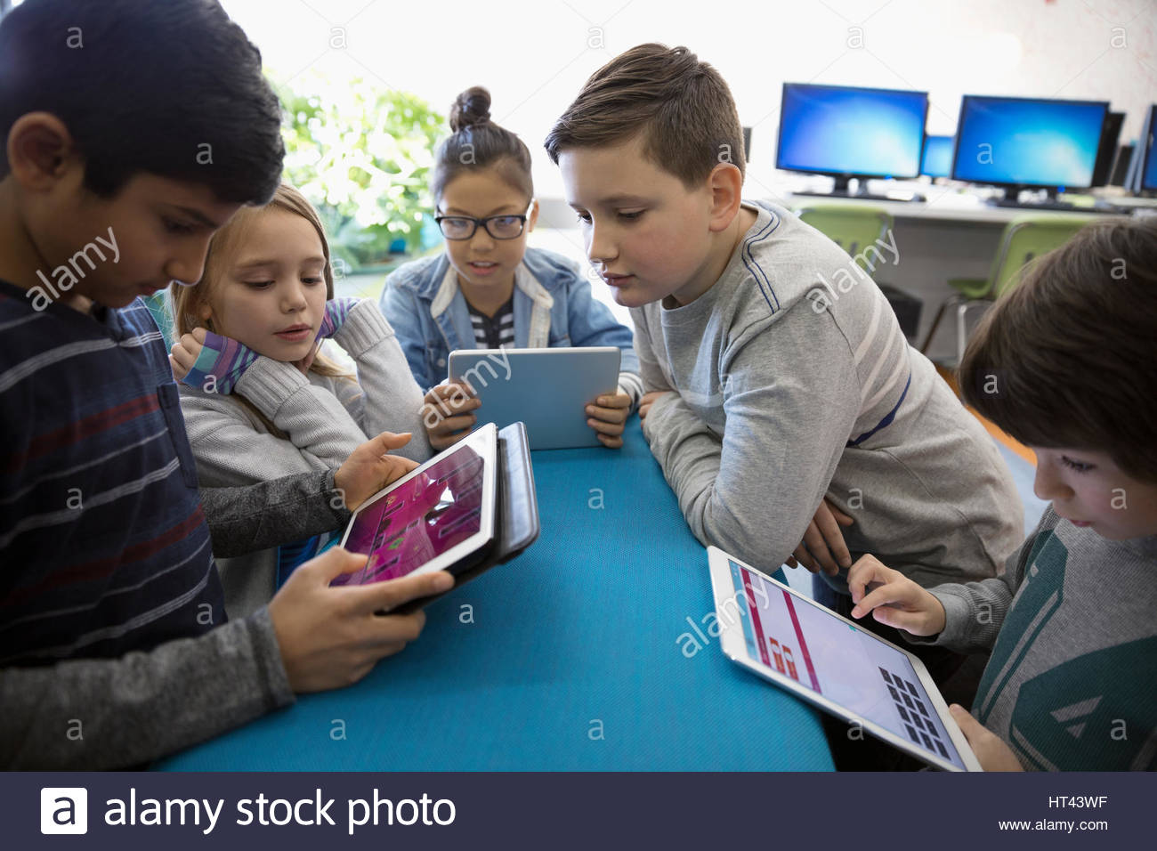 Pre-adolescent students using digital tablets in library Stock Photo ...