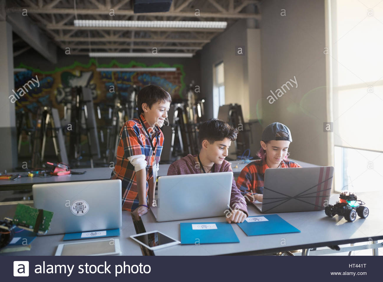 Pre-adolescent boys programming robotics at laptops in classroom Stock ...