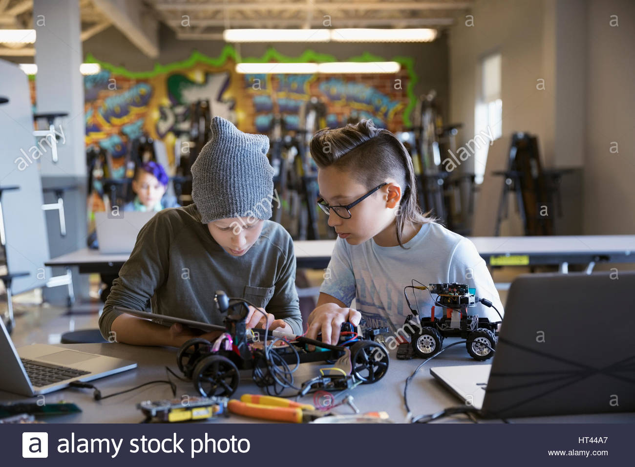 Pre-adolescent boys assembling and programming robotics at digital ...
