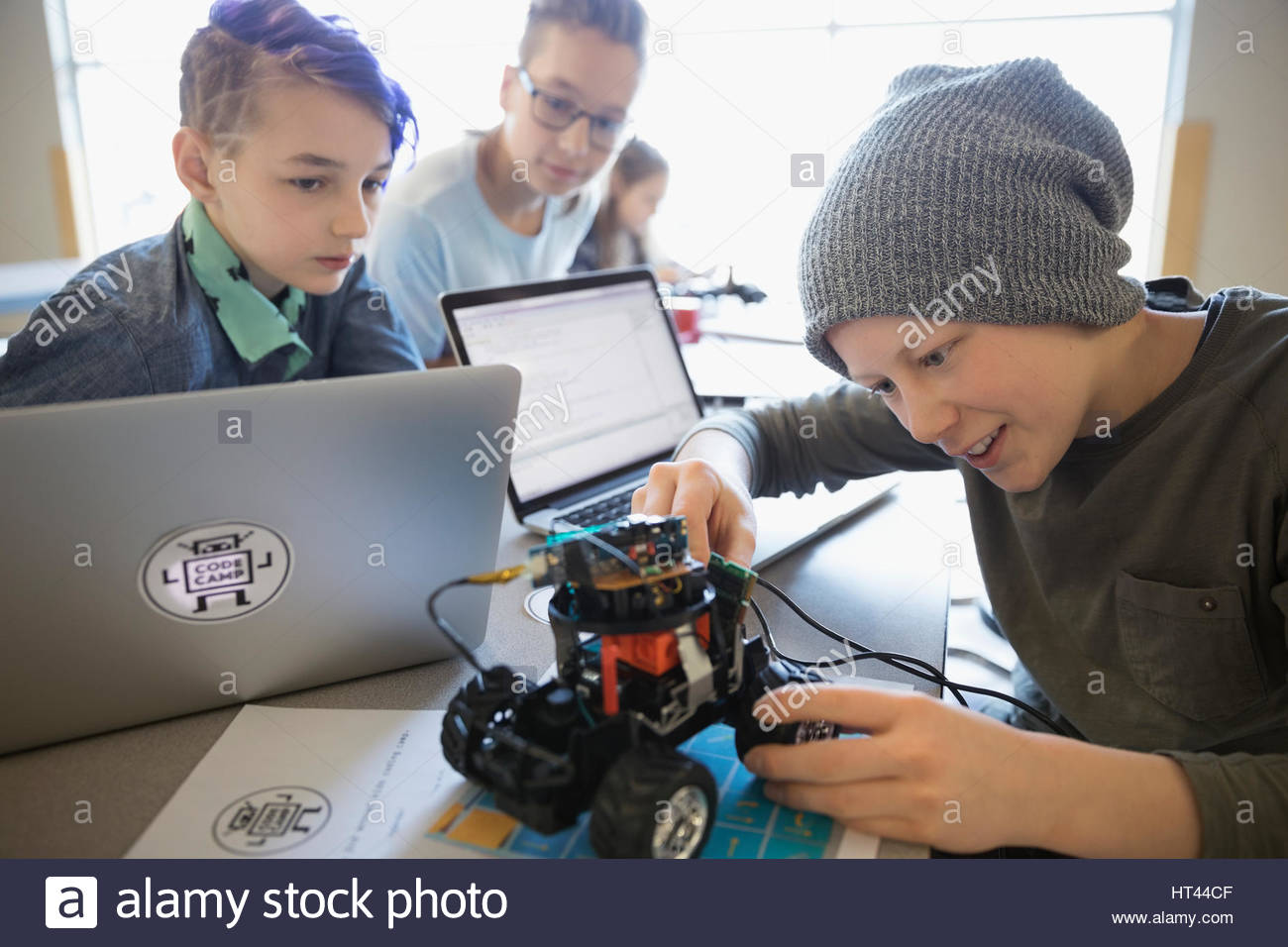Pre-adolescent boys and girl assembling and programming robotics at ...