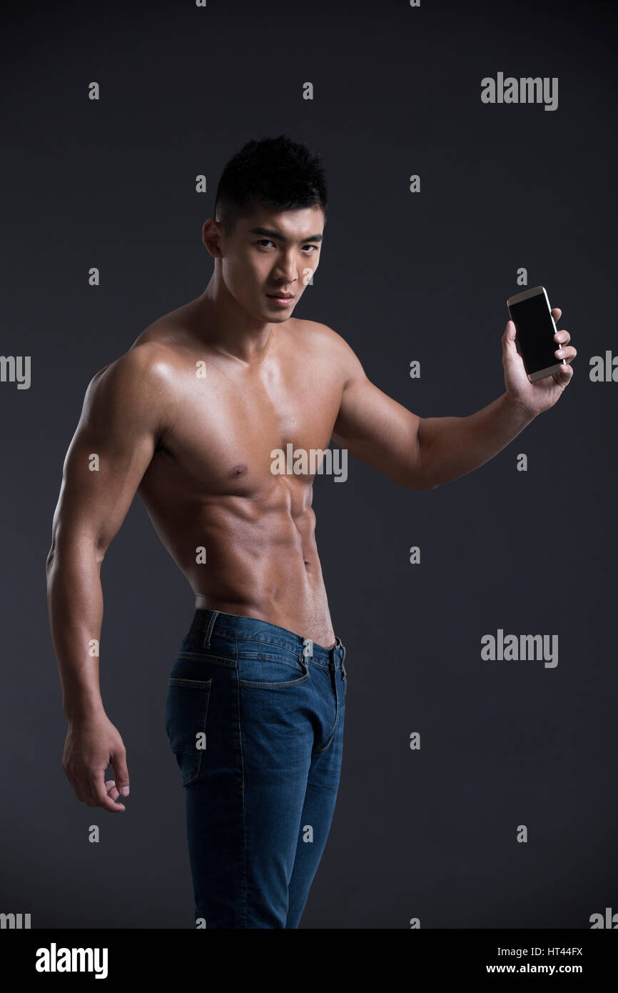 Young muscular man with a smart phone Stock Photo - Alamy