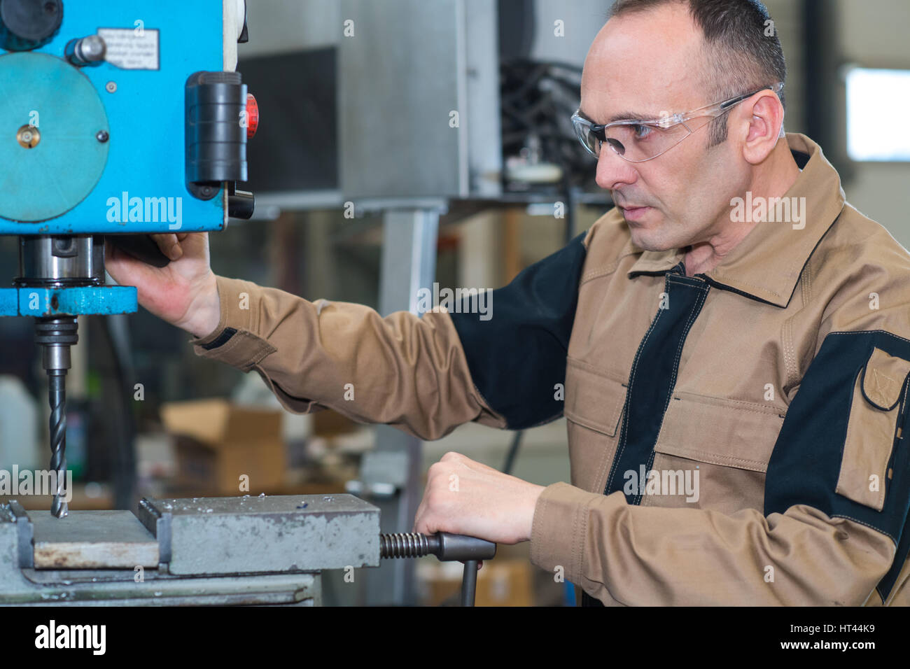 Worker using bench drill Stock Photo - Alamy