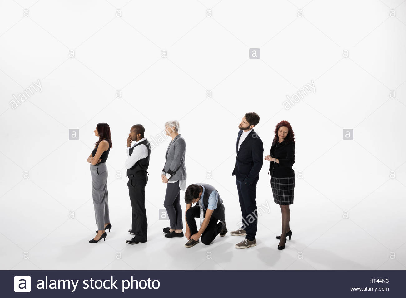 Business people waiting in a row, tying shoe in queue against white ...