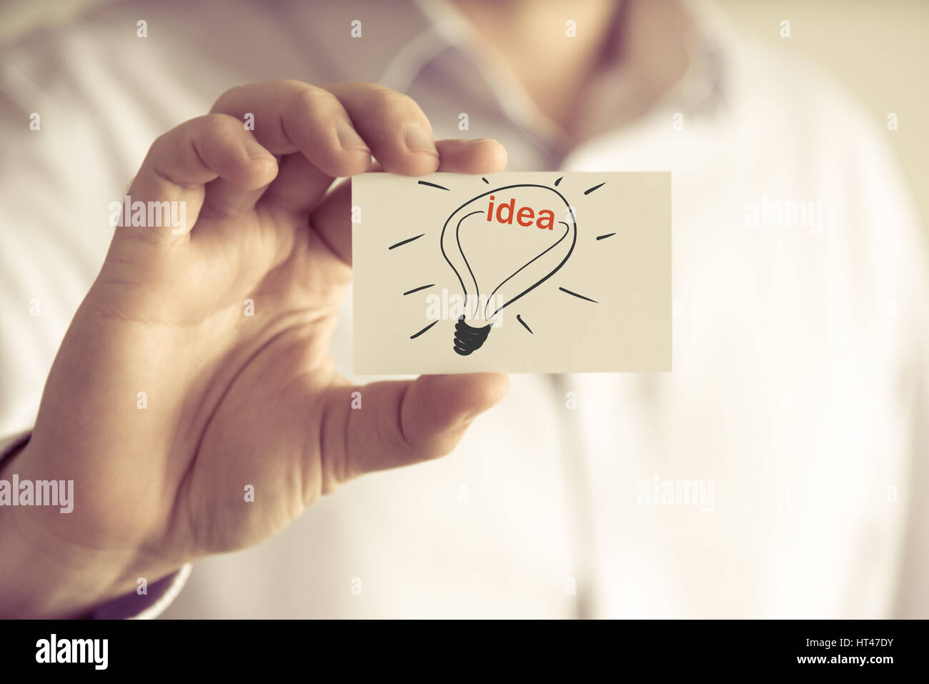 Closeup on businessman message card with light bulb symbol and text ...