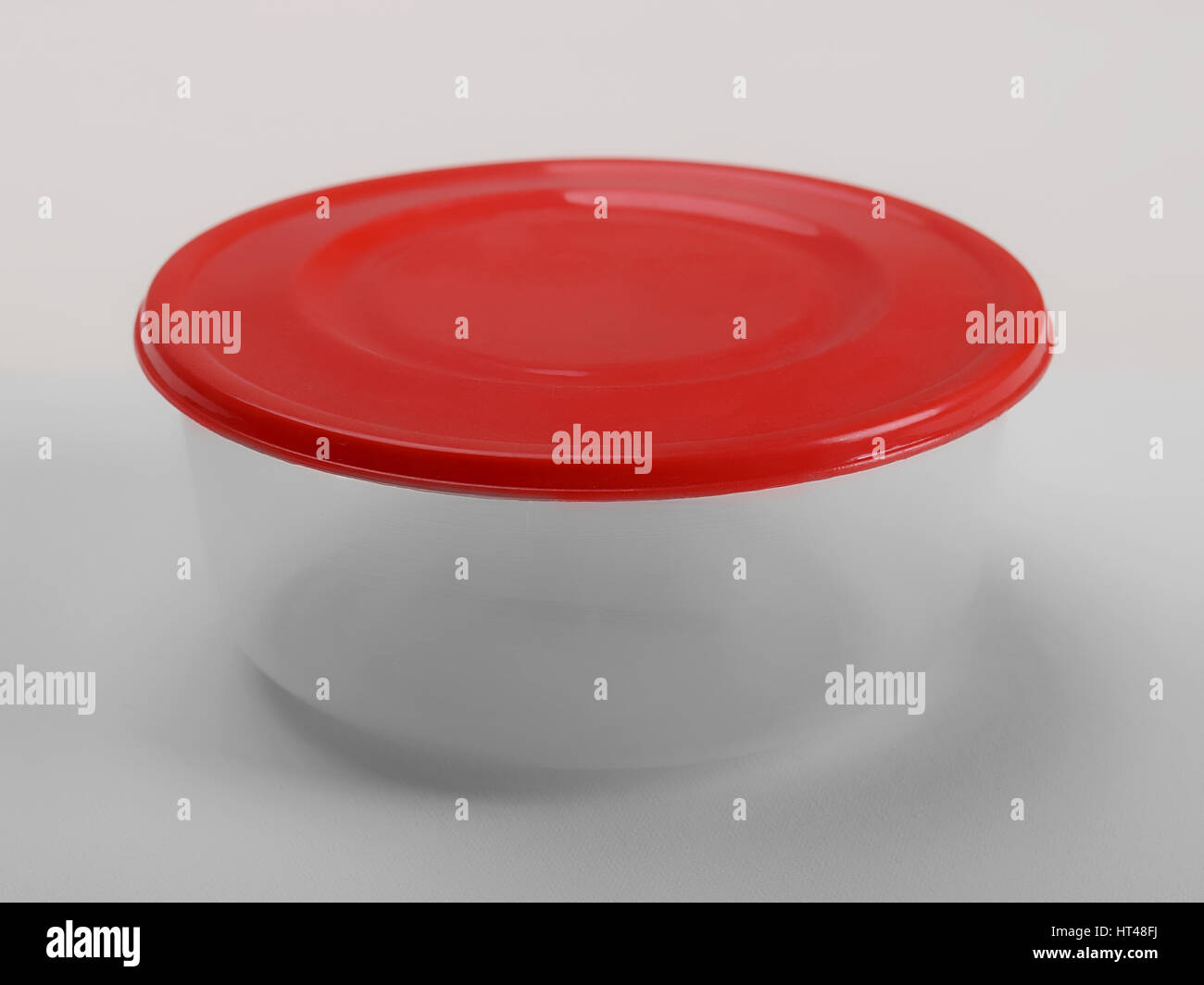 Round plastic container with red lid on white background Stock Photo ...