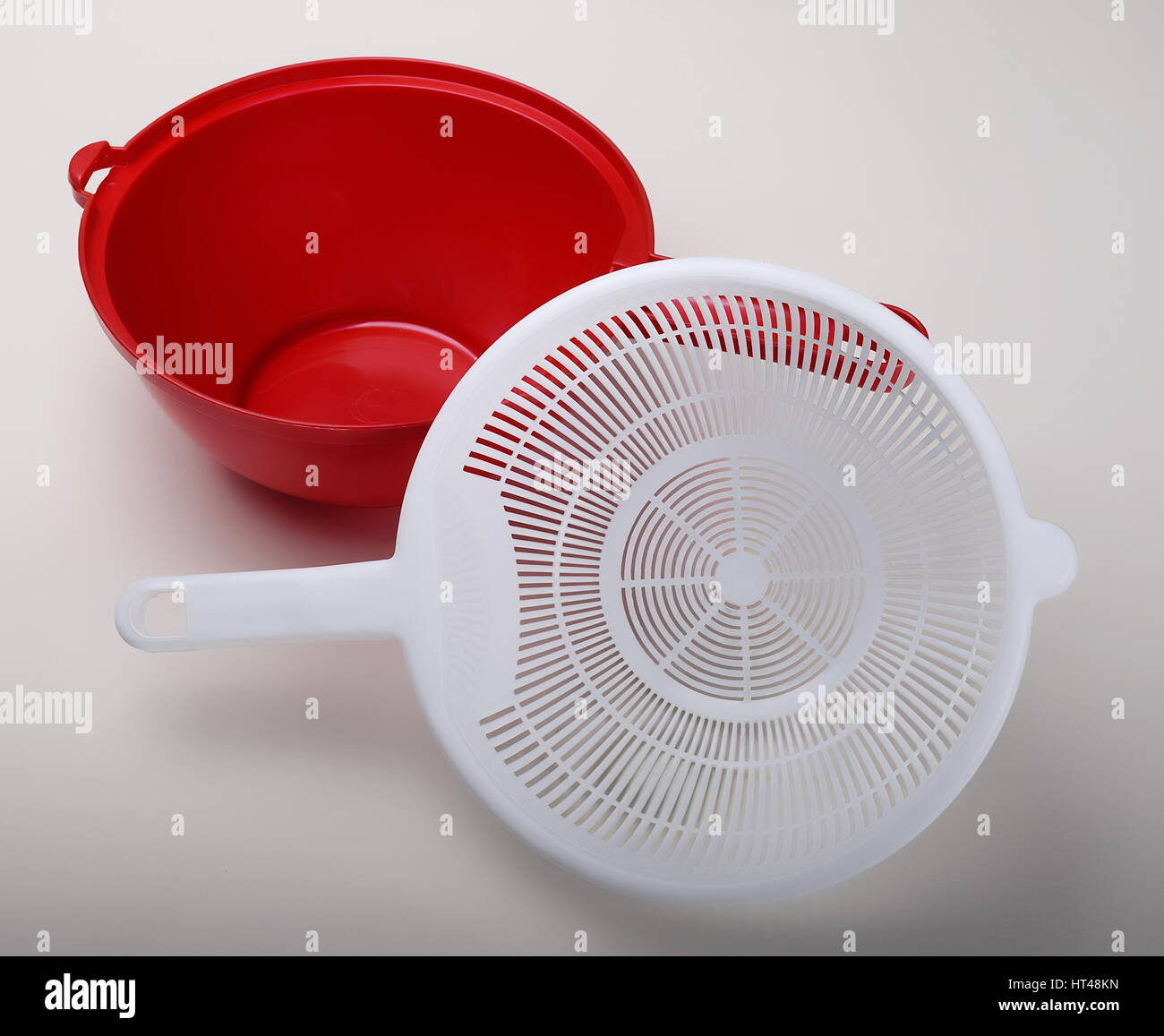 White plastic colander near red bowl isolated on white background Stock ...