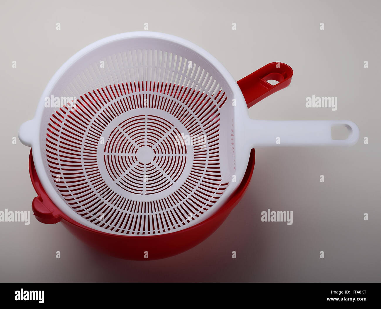 White plastic colander in red bowl isolated on white background Stock ...