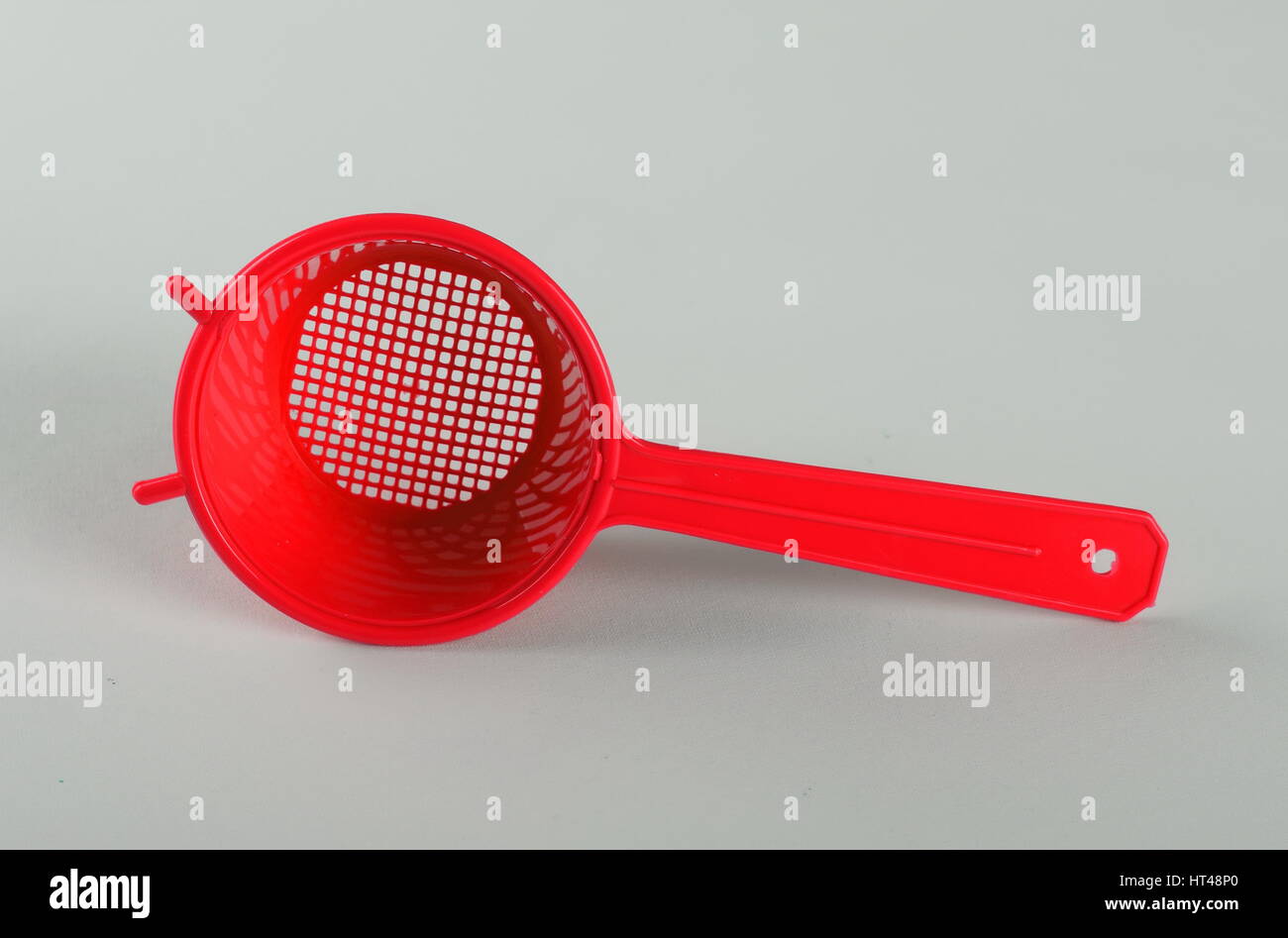 Red plastic tea strainer isolated on white background Stock Photo - Alamy