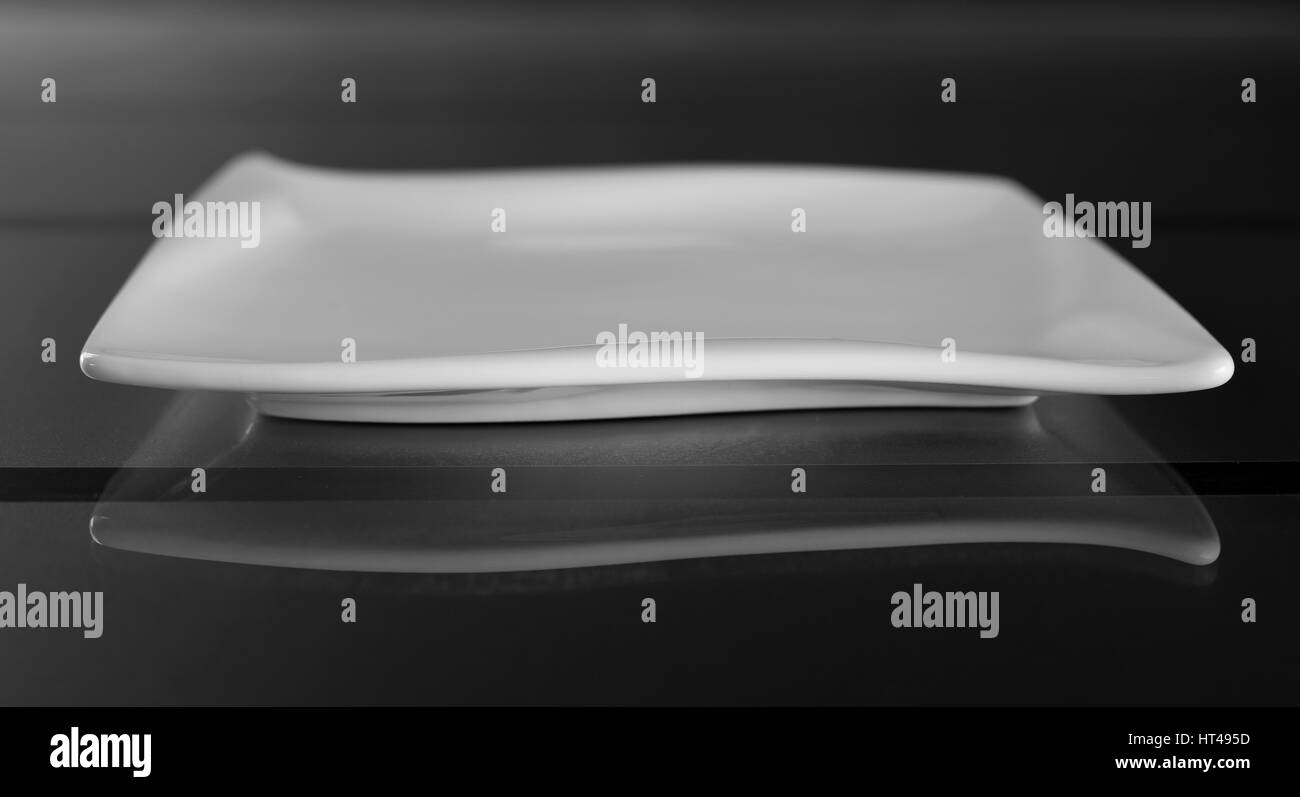 Porcelain square shallow dish with blurred background Stock Photo - Alamy