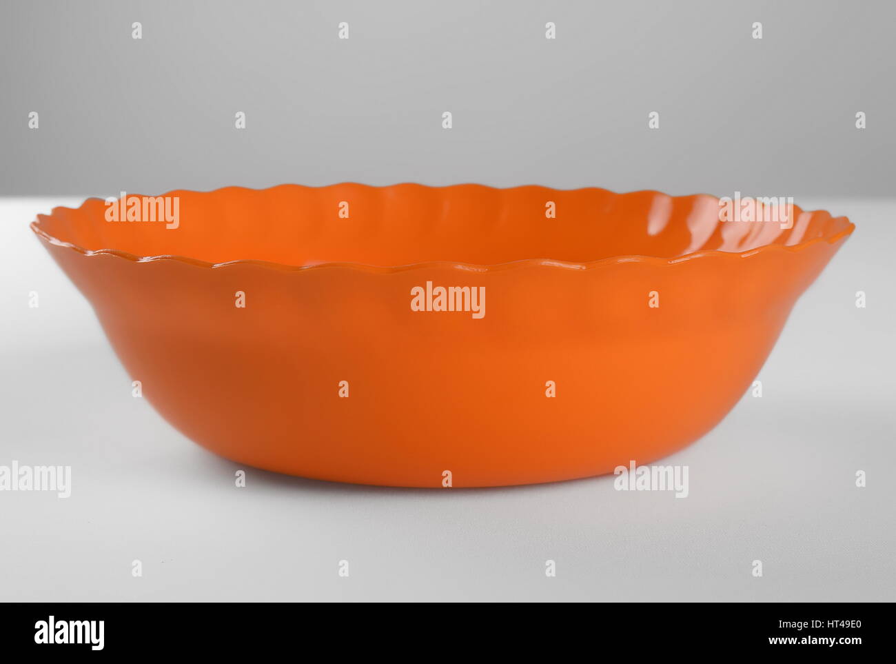 Orange round plastic deep dish. front view Stock Photo - Alamy