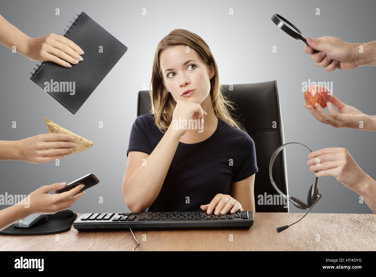 businesswoman at her desk looking up thinking about something ...