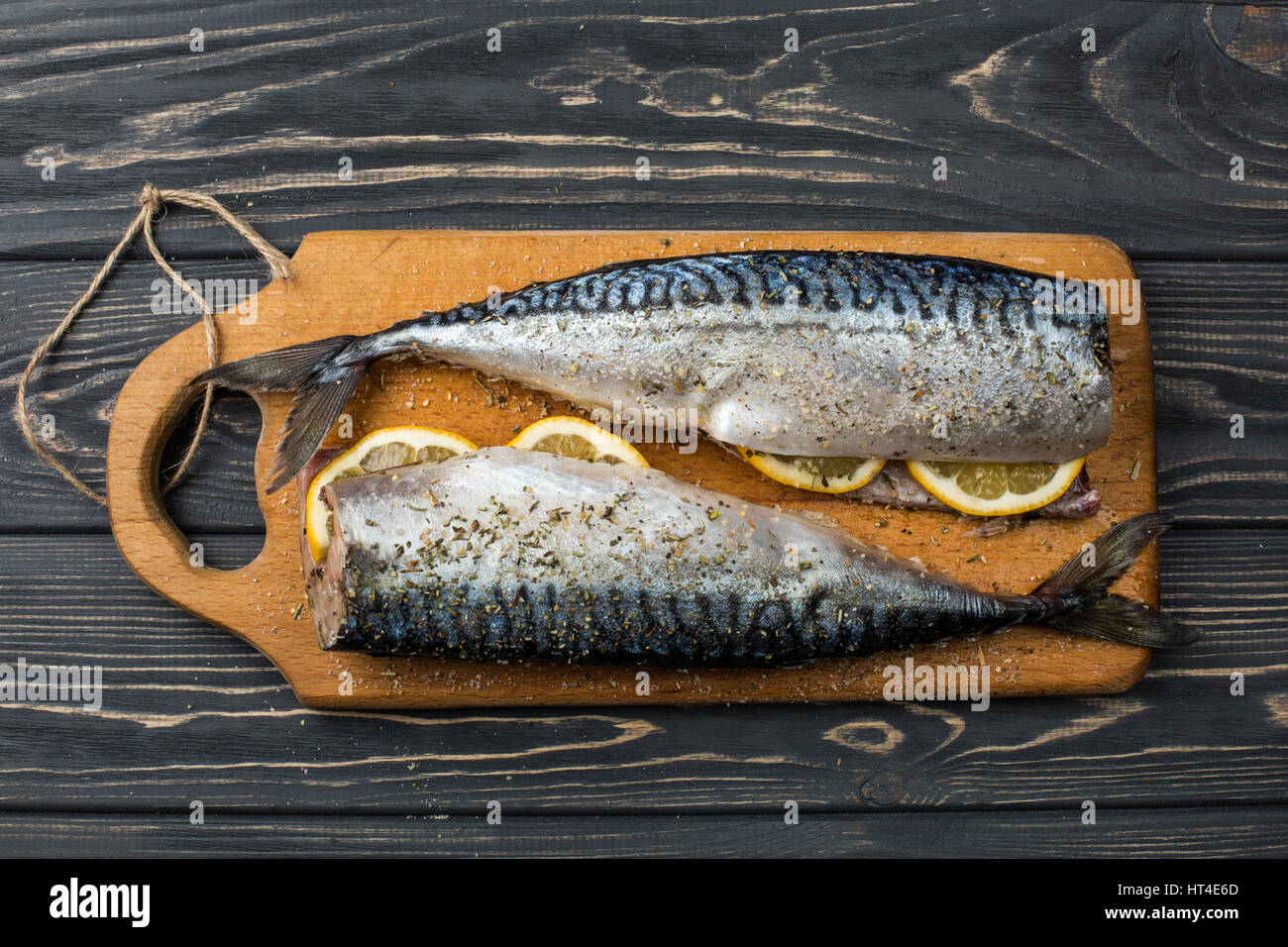 Fresh fish. Raw mackerel with salt, lemon and spices on a dark ...