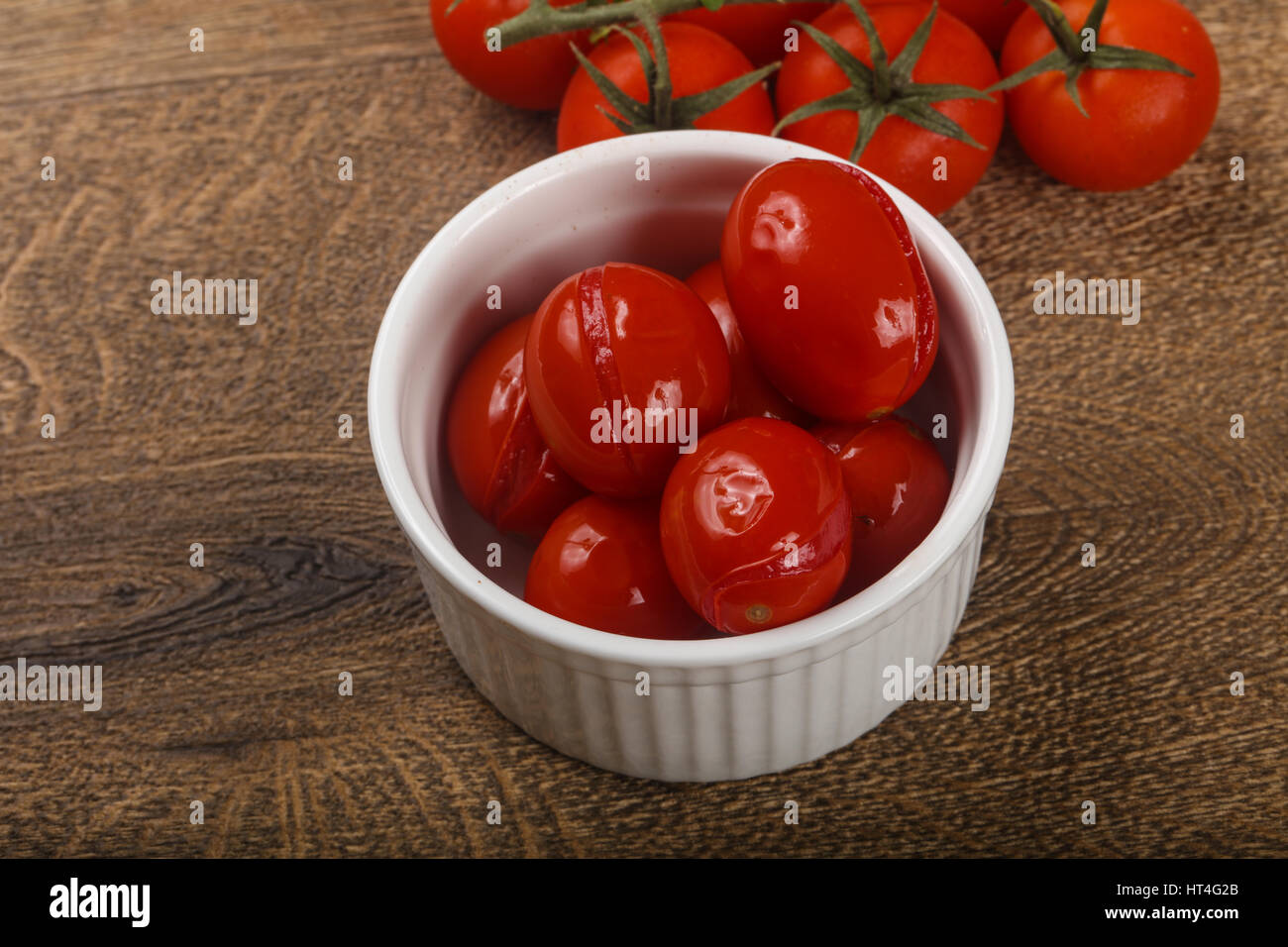 Pickled cherry tomatoes heap on the wooden background Stock Photo - Alamy