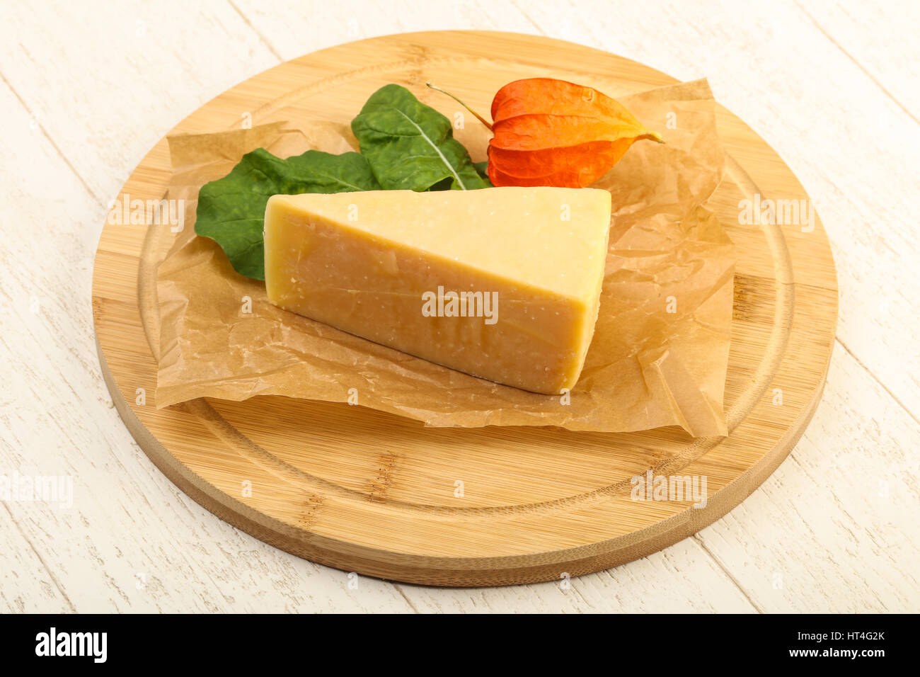 Parmesan cheese slice with salad leaves over the wooden background ...