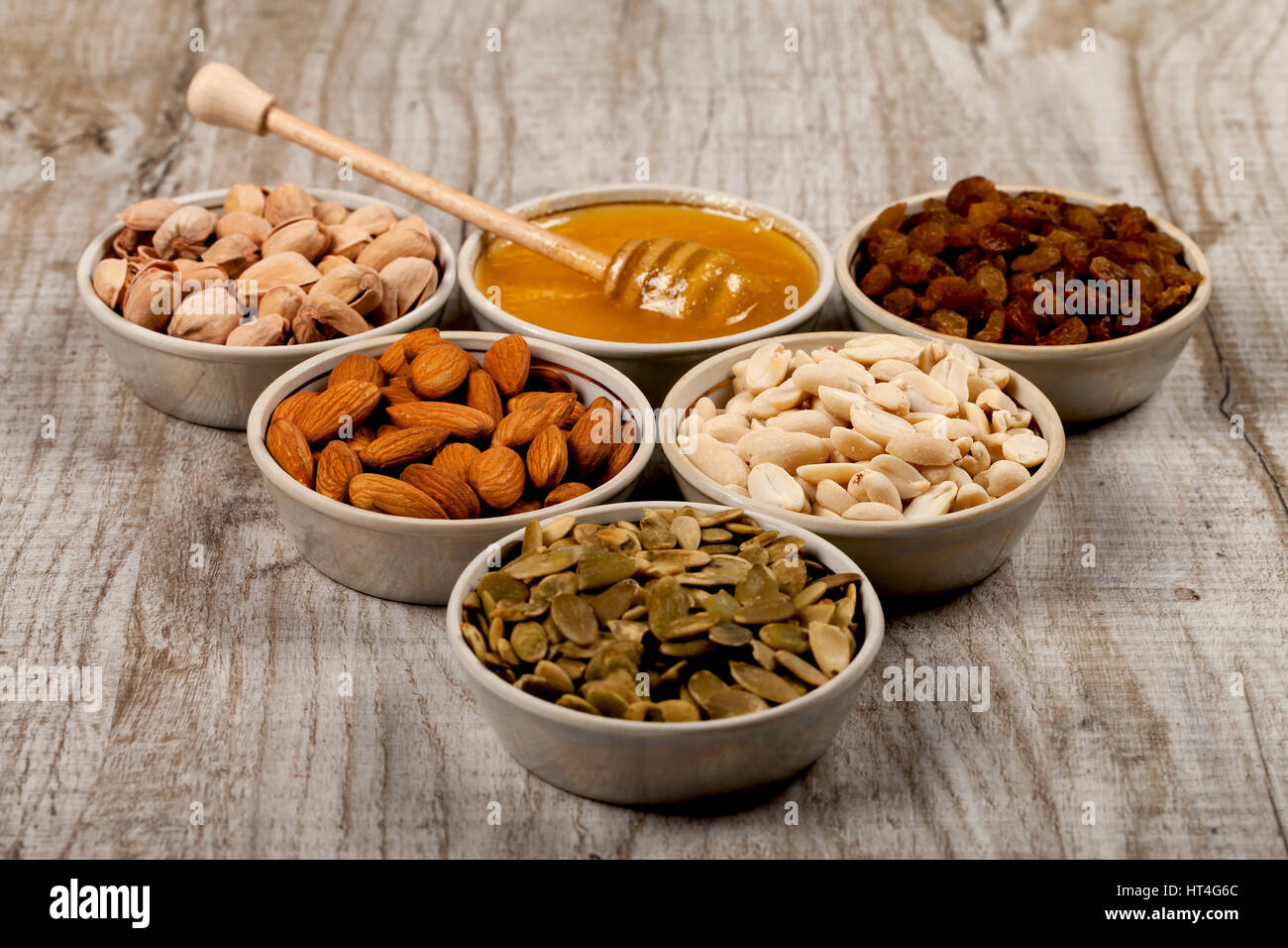 Pistachios, almonds, peanuts, pumpkin seeds, raisins and honey in ...