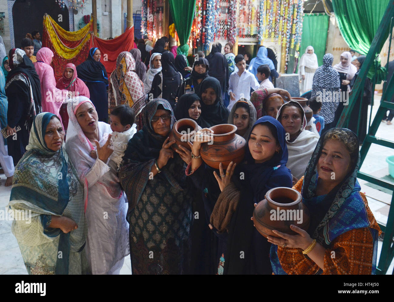 Lahore, Pakistan. 6th Mar, 2017. Pakistani women devotees bringing ...