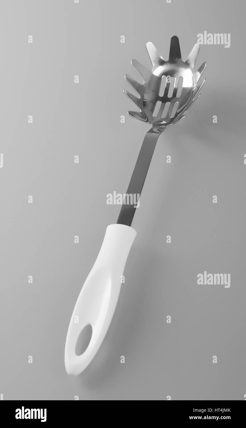 Spaghetti draining utensil with plastic handle on gray background Stock ...