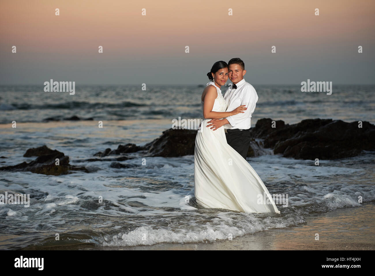 Couple stand on beach waves hi-res stock photography and images - Alamy