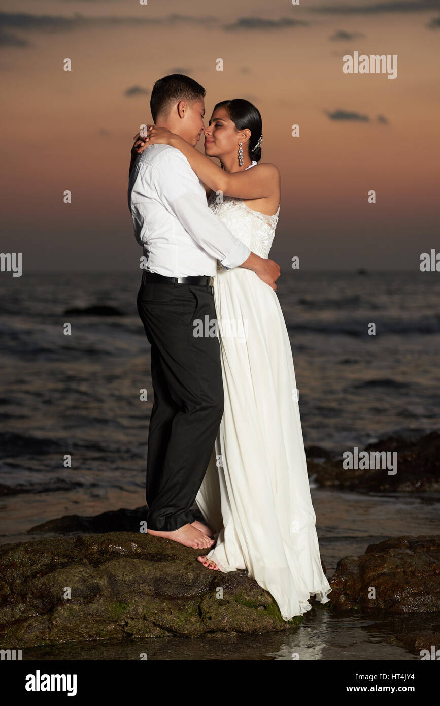 Hispanic young couple kissing on beach during scenic sunset on exotic ...