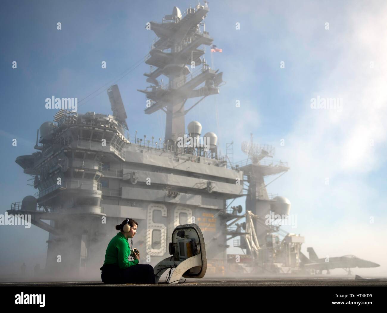 A U.S. sailor works on the flight deck aboard the USN Nimitz-class ...