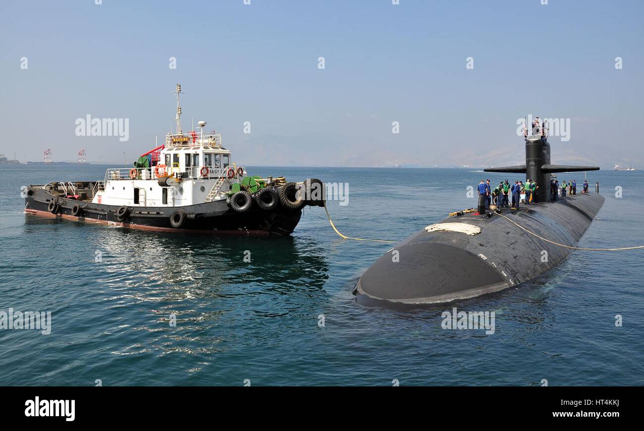 A tug boat guides the USN Los Angeles-class fast-attack submarine USS ...