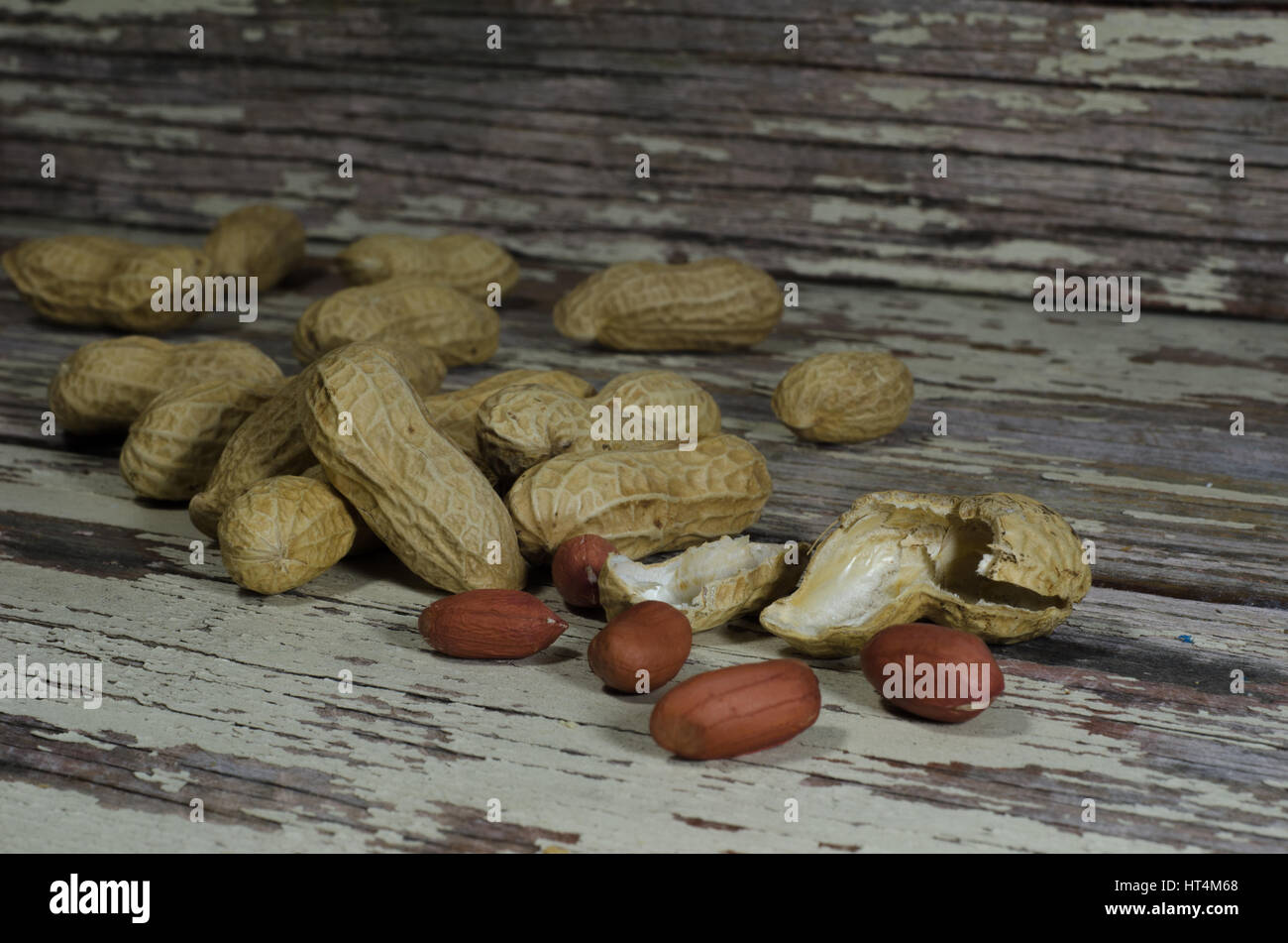 Raw peanuts in their shells on a rustic weathered board Stock Photo - Alamy