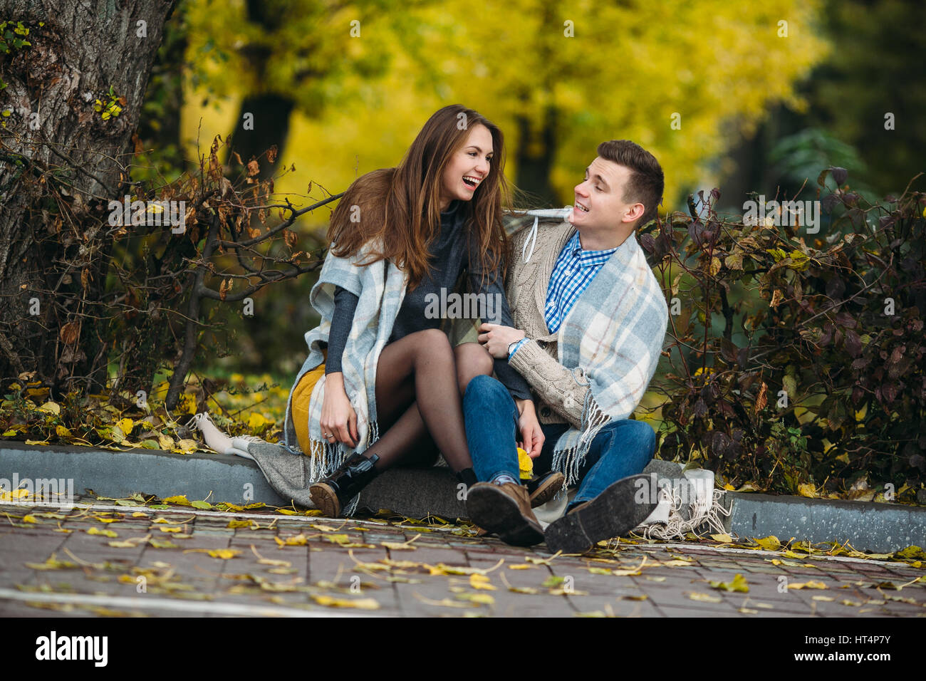 Love and affection between a young couple at the park in autumn season ...