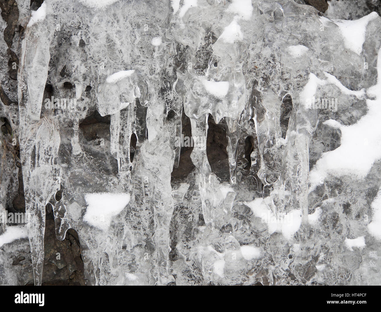 Ice and icicles on a cliff made from melt water trickling down, a close ...