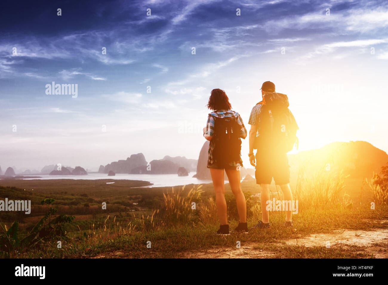 Two hikers backpackers view sunrise sunset Stock Photo - Alamy