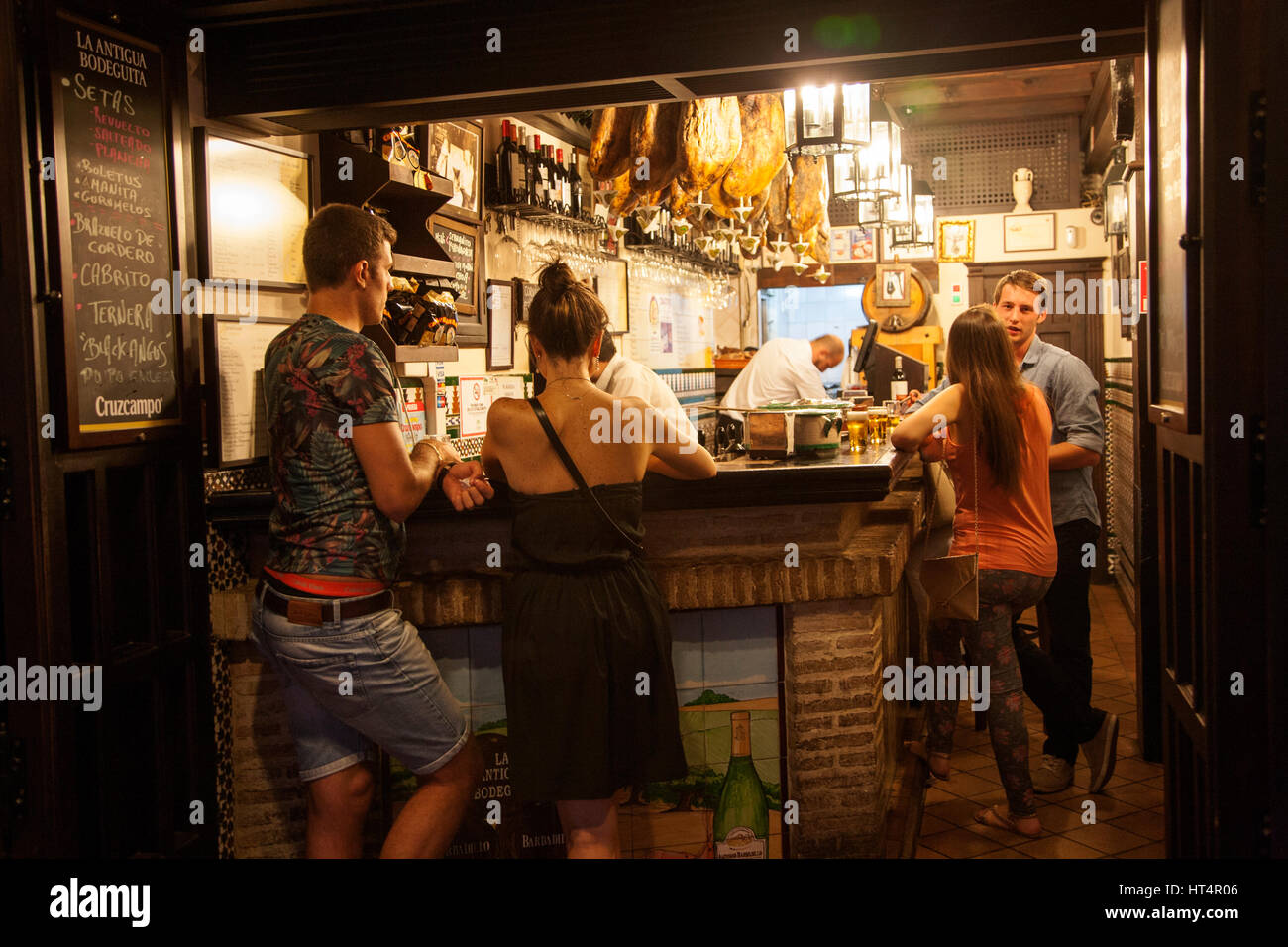 People inside typical traditional tapas bar in city centre of Seville ...