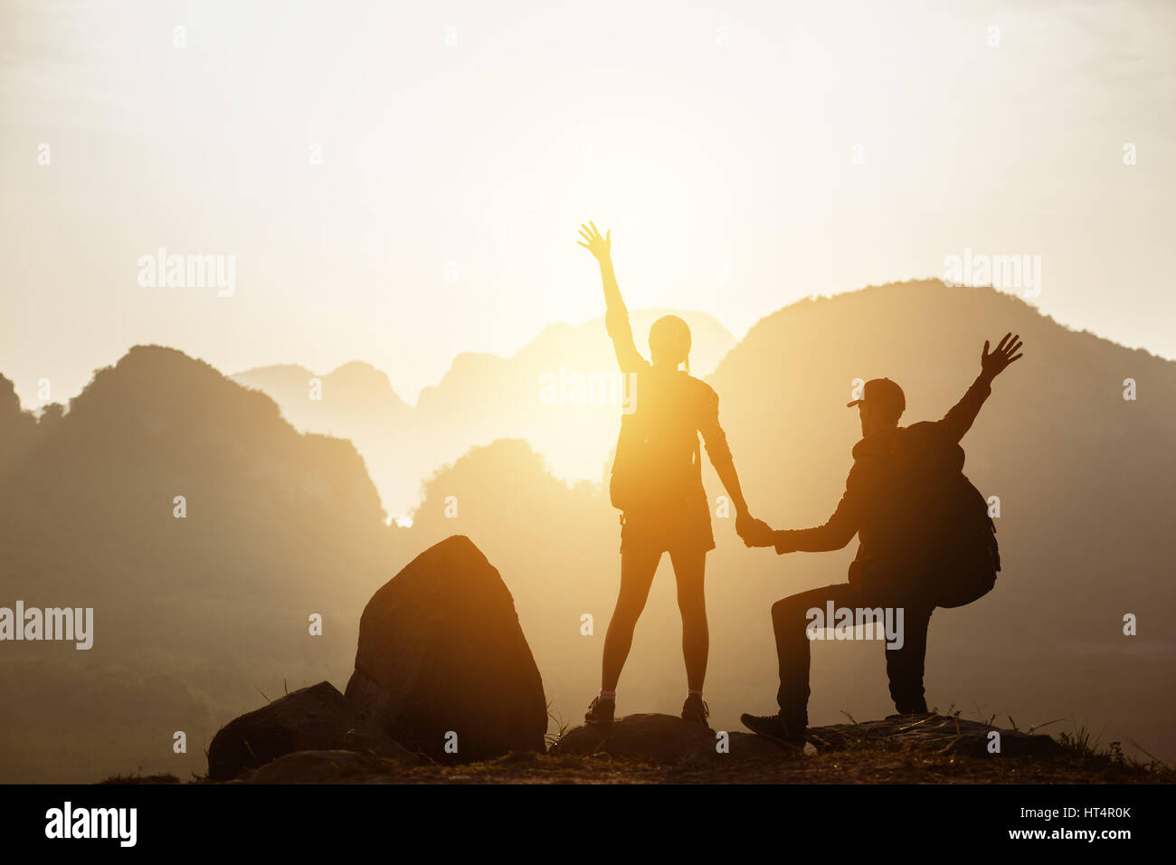 Couple backpackers hikers mountains sunset Stock Photo - Alamy