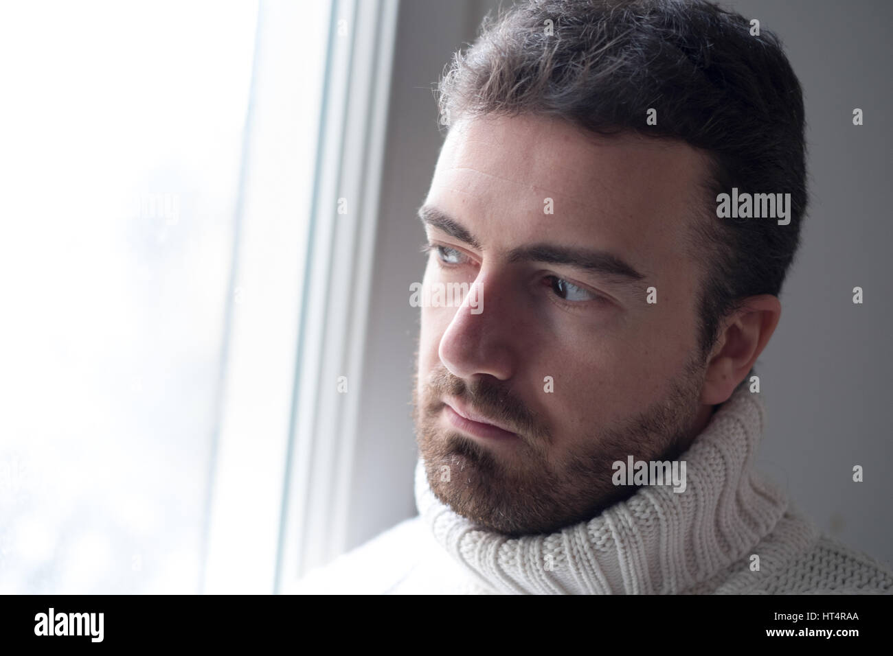 Portrait of sad man looking out of a window Stock Photo - Alamy