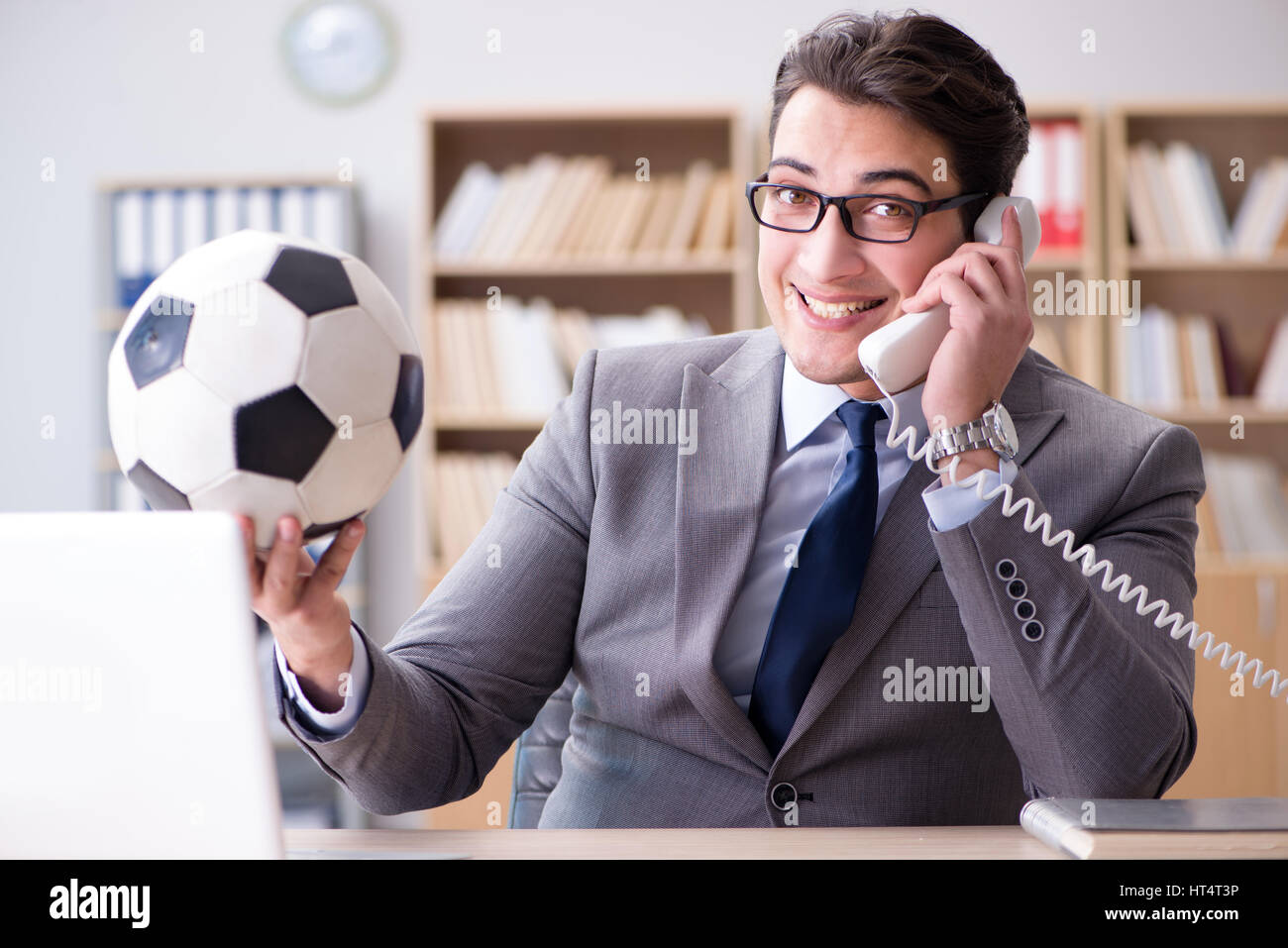 Businessman with football ball in office Stock Photo - Alamy